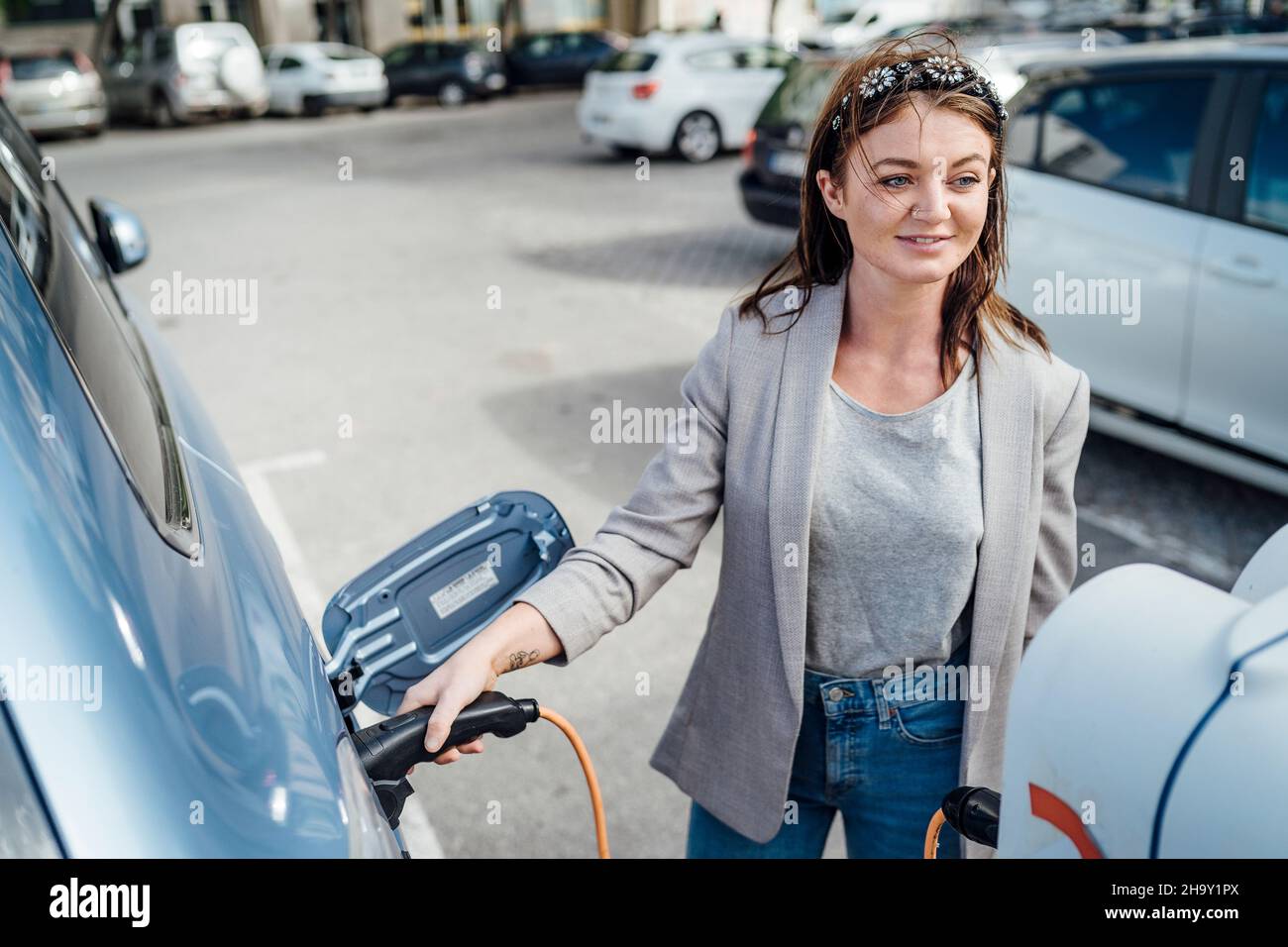 Woman charging an electric car in urban settings, Faro, Portugal Stock ...