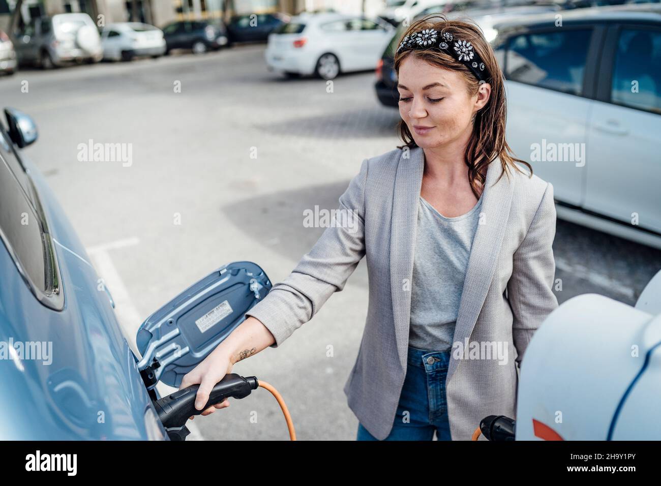 Woman charging an electric car in urban settings, Faro, Portugal Stock ...