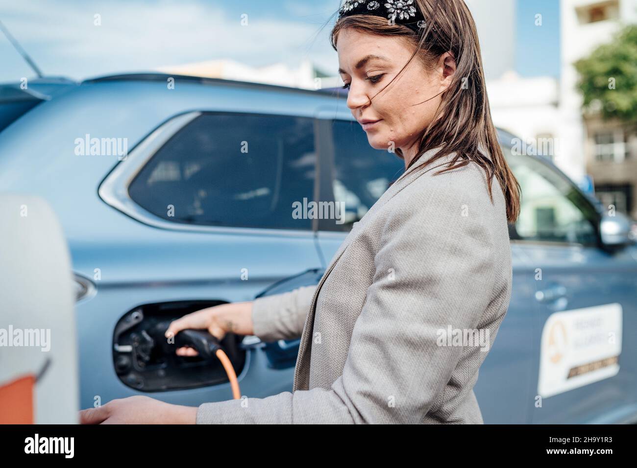 Woman charging an electric car in urban settings, Faro, Portugal Stock ...