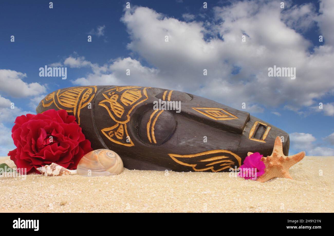 Wooden Mask on Sand With Flowers and Blue Sky Background Stock Photo ...