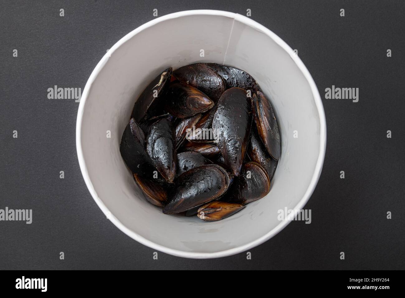 Fresh stuffed mussels in bucket on dark stone background Stock Photo ...
