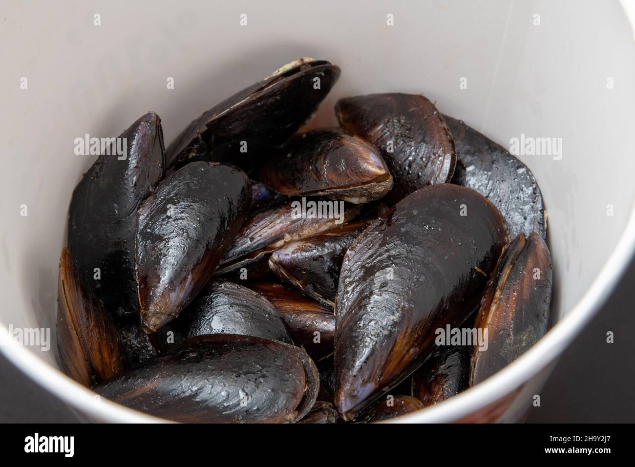 Fresh stuffed mussels in bucket on dark stone background Stock Photo ...