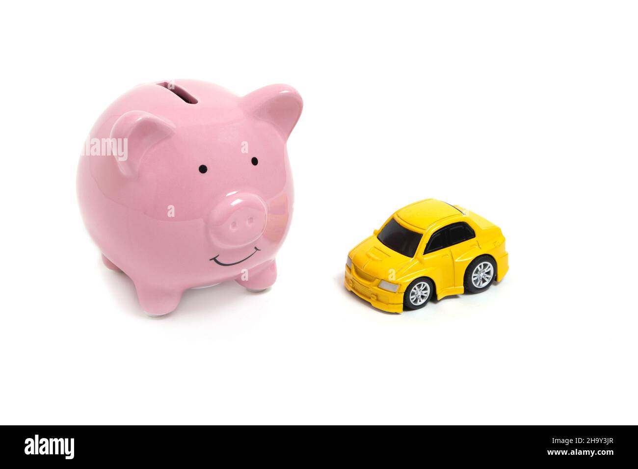 Piggy bank and yellow car on white background Stock Photo - Alamy