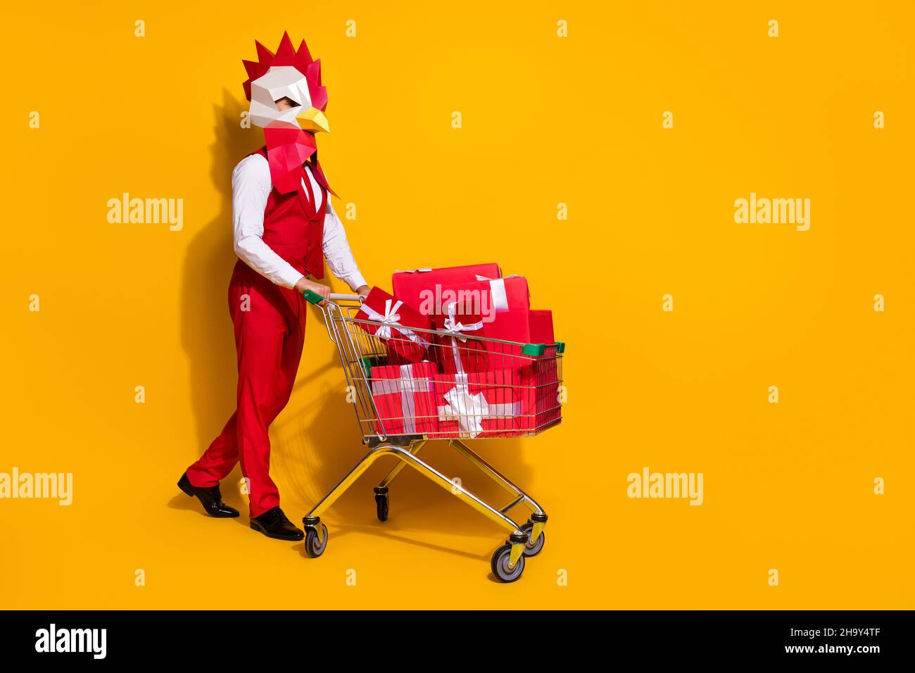 Photo of retail customer ride shopping present cart wear rooster mask ...