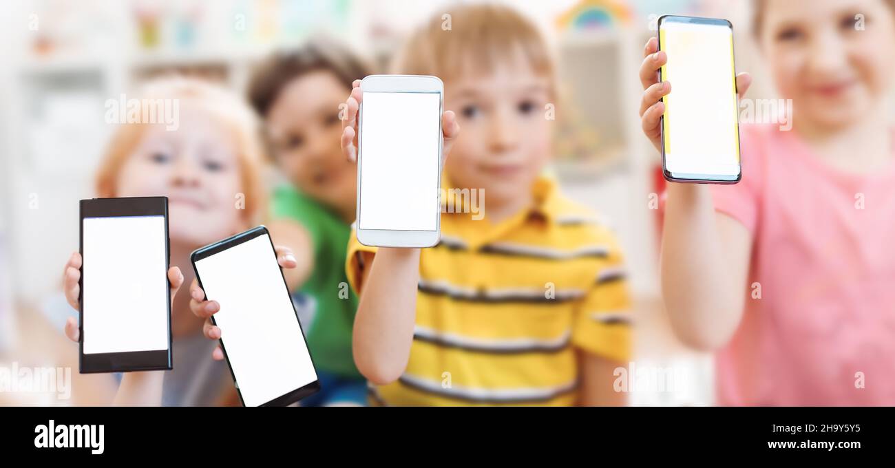 Group of children holding in their hands smartphones with mock-up ...