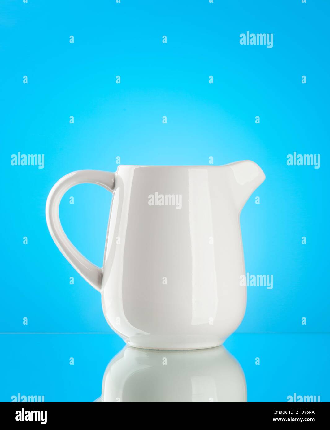 Milk pitcher over blue background. Dairy product Stock Photo - Alamy