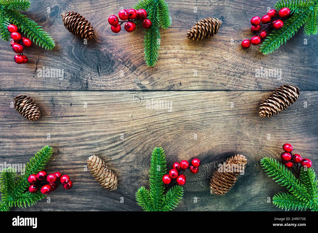 Christmas frame with fir branches and red berries as decoration on dark ...