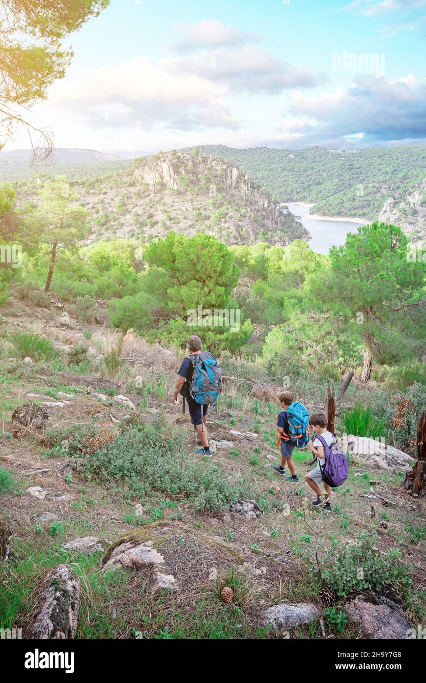 Boy scout monitor walking on a forest trail with two young hikers Stock ...