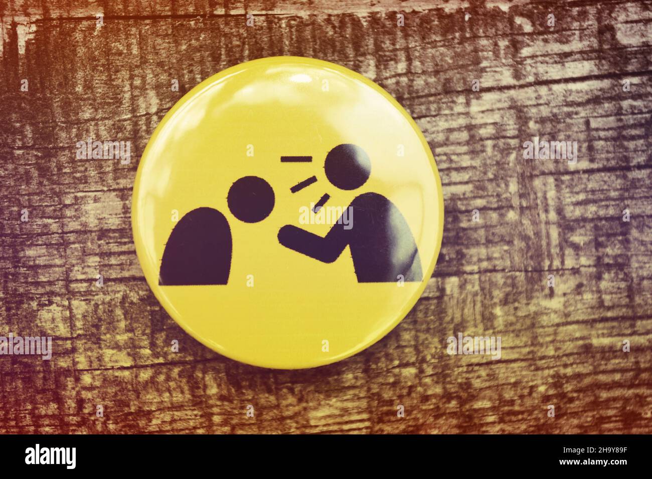 Yellow badge with black painted humans Stock Photo - Alamy