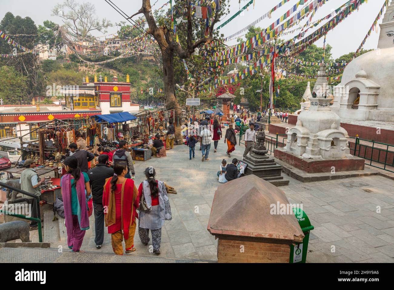 Visitors walk past vendors' stalls and Buddhist stupas in the ...
