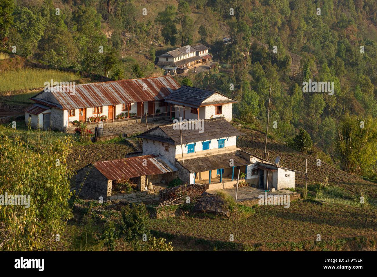 Traditional farm houses on a steep hillside near the Himalayan foothill ...