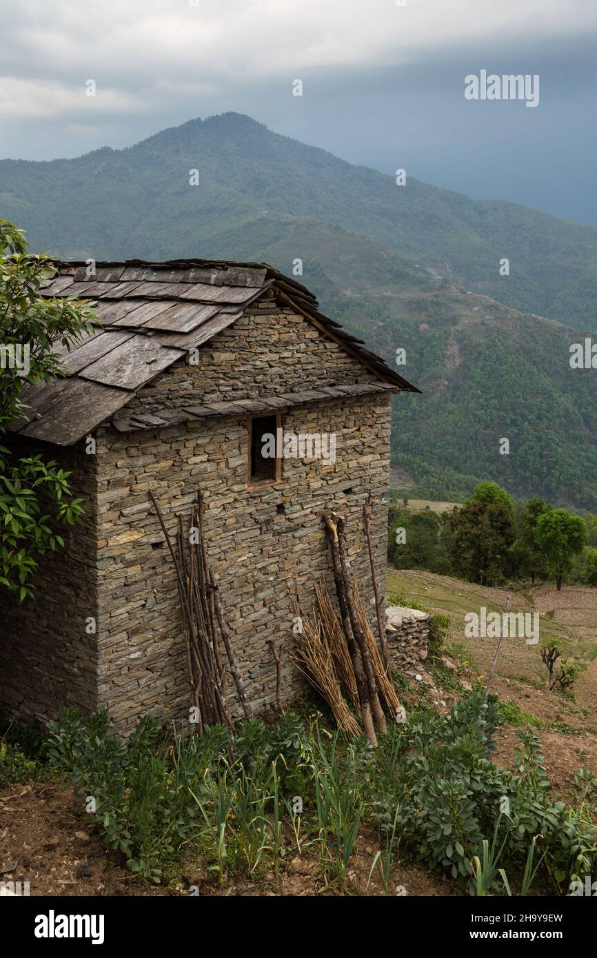 A traditional Nepalese farm building of stone with a slate tile roof in ...