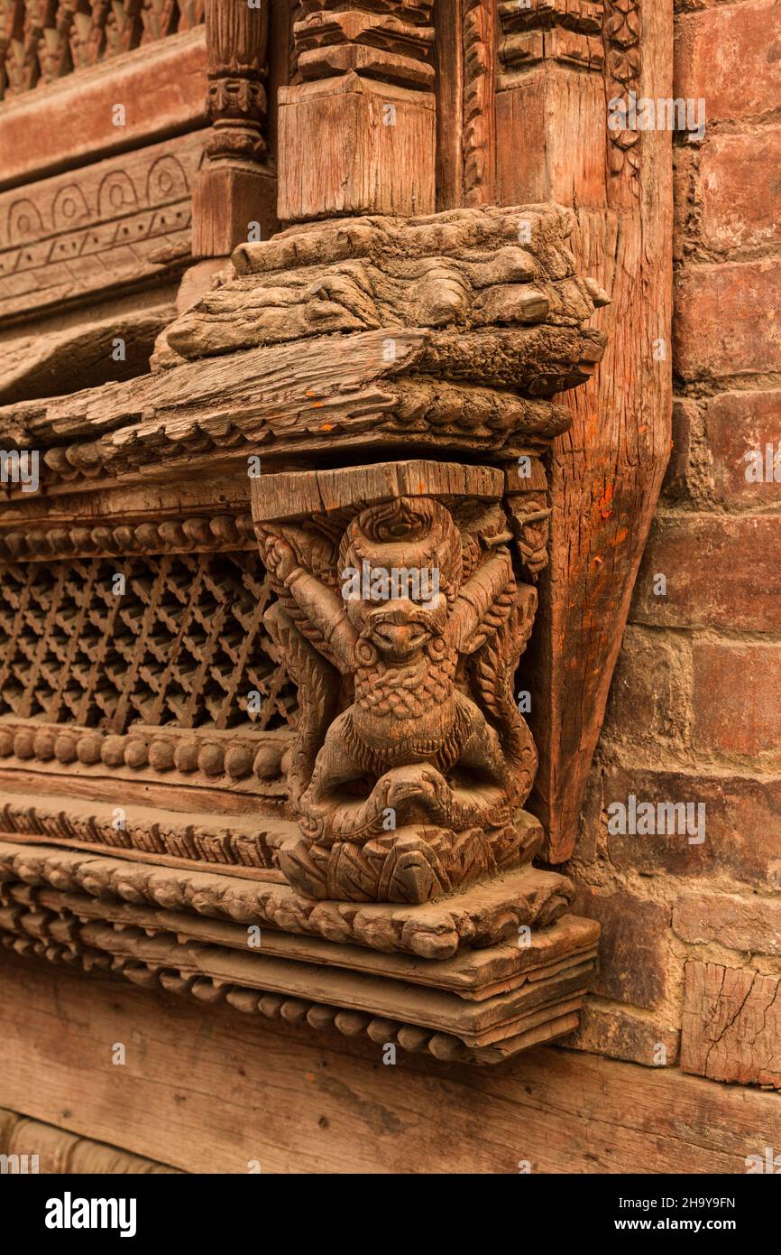 A detalied wood carving of Garuda with the Naga or serpents on window ...