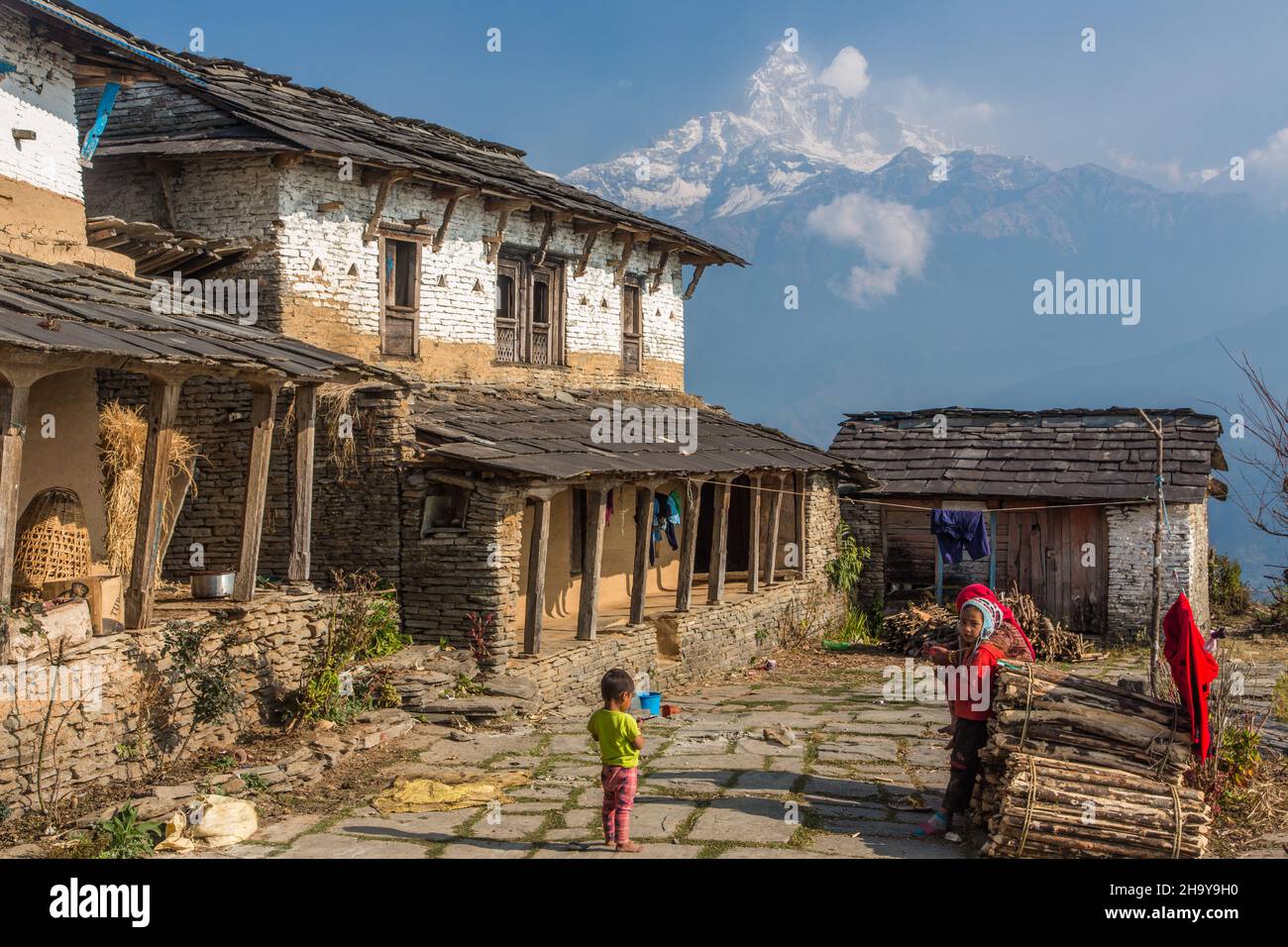 Children in front of a traditional farmhouse in the Himalayan foothill ...