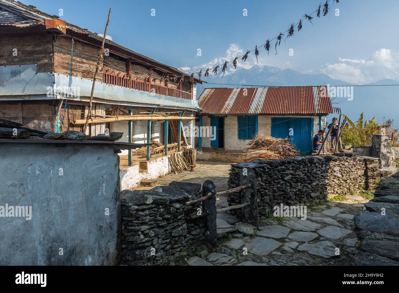Two boys play in front of a traditional Nepalese farm house in the ...