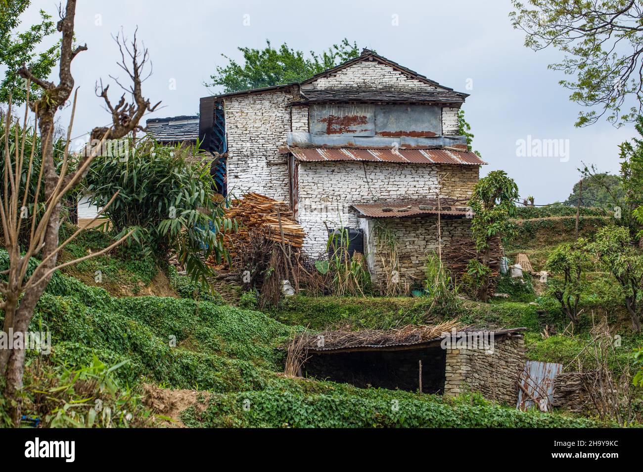A traditional Nepalese farm house built of stone with a slate tile roof ...