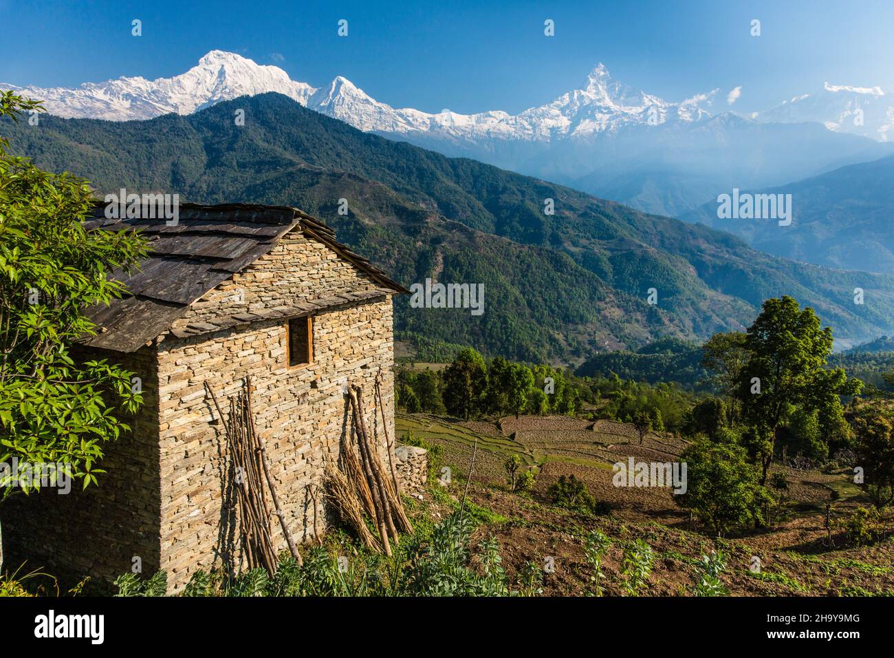 A traditional Nepalese farm building of stone with a slate tile roof in ...