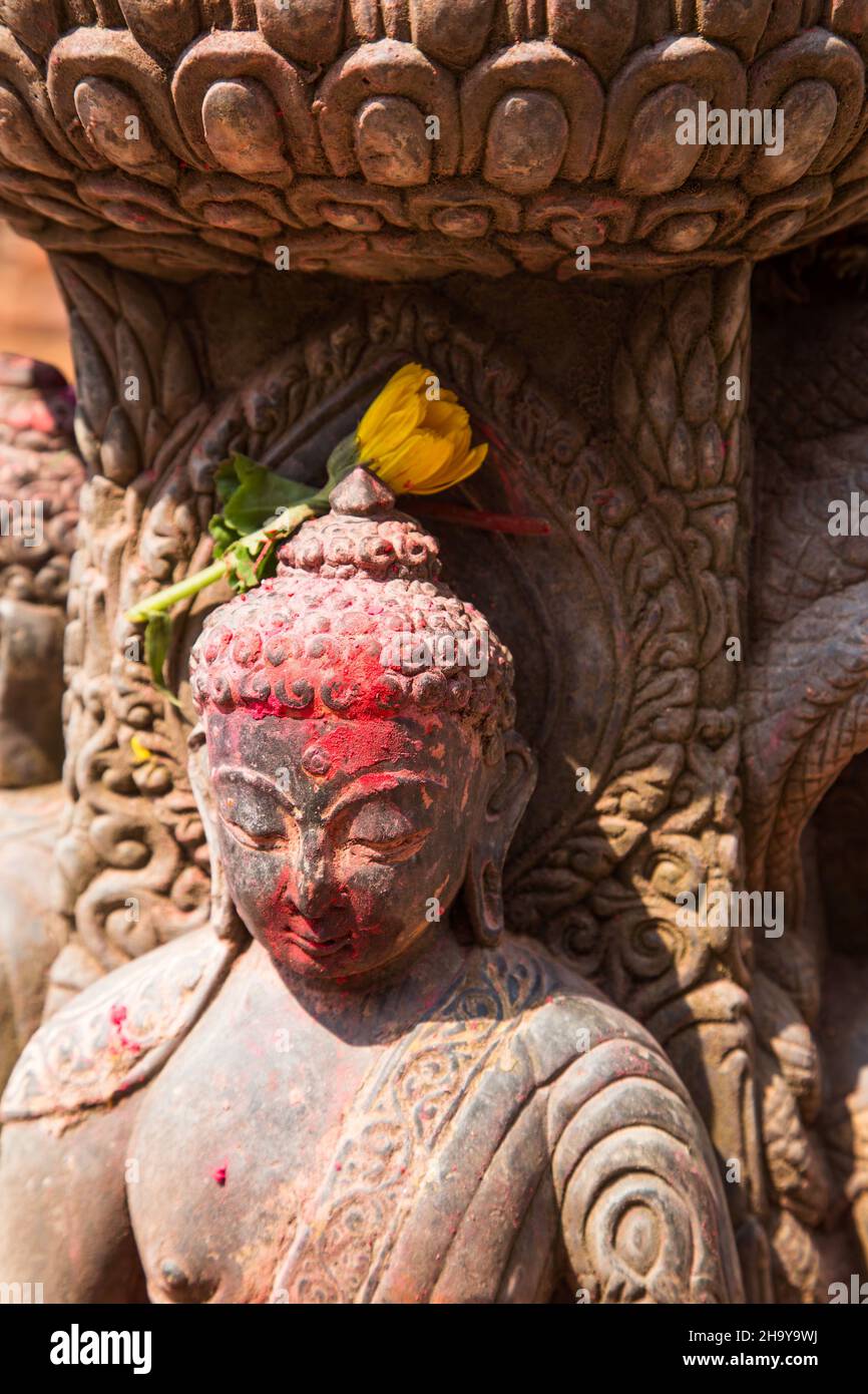 A flower offering on a statue of Buddha in the medieval Newari village ...