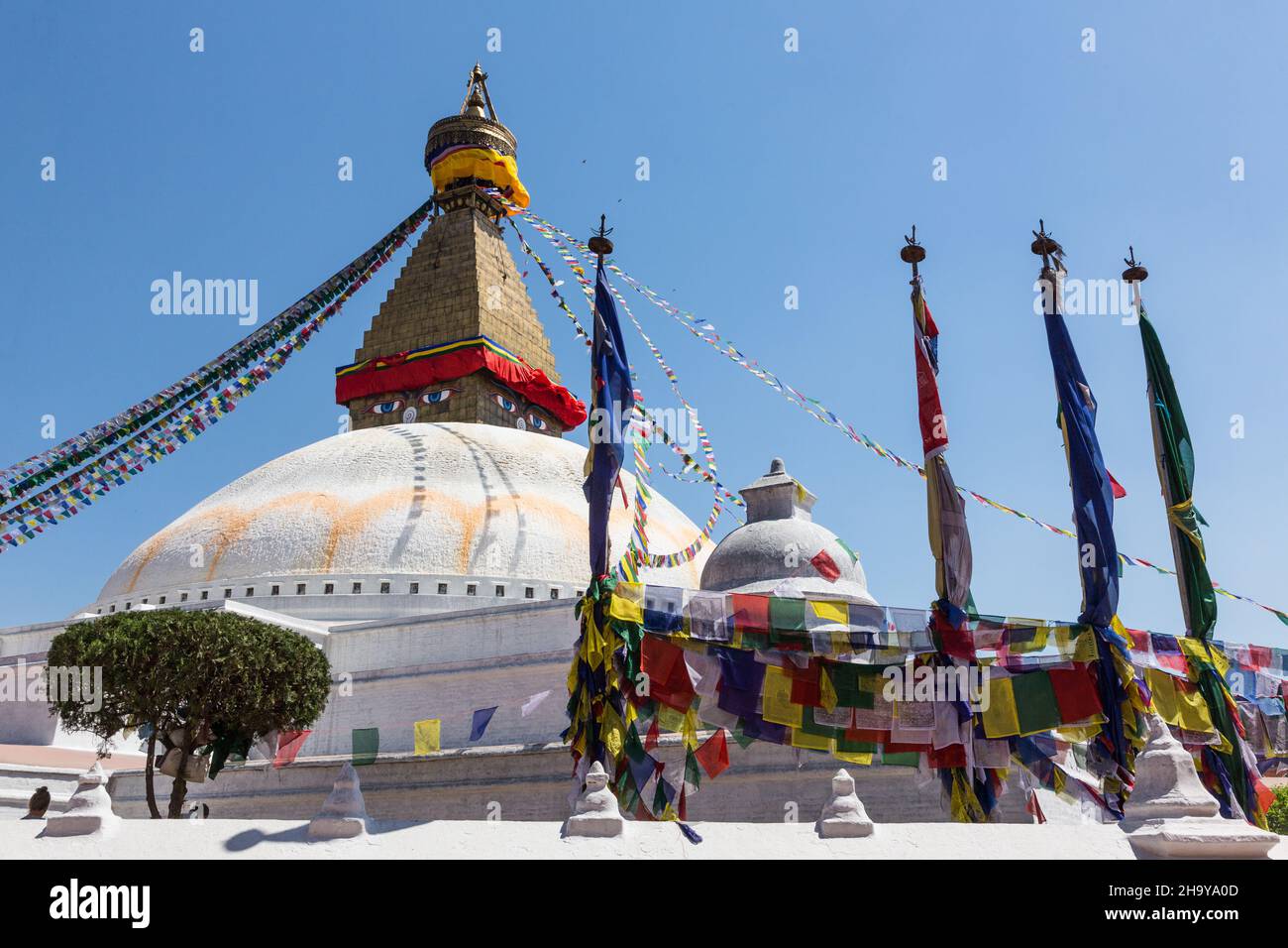 The dome, harmika and spire of the Boudhanath Stupa with prayer flags ...