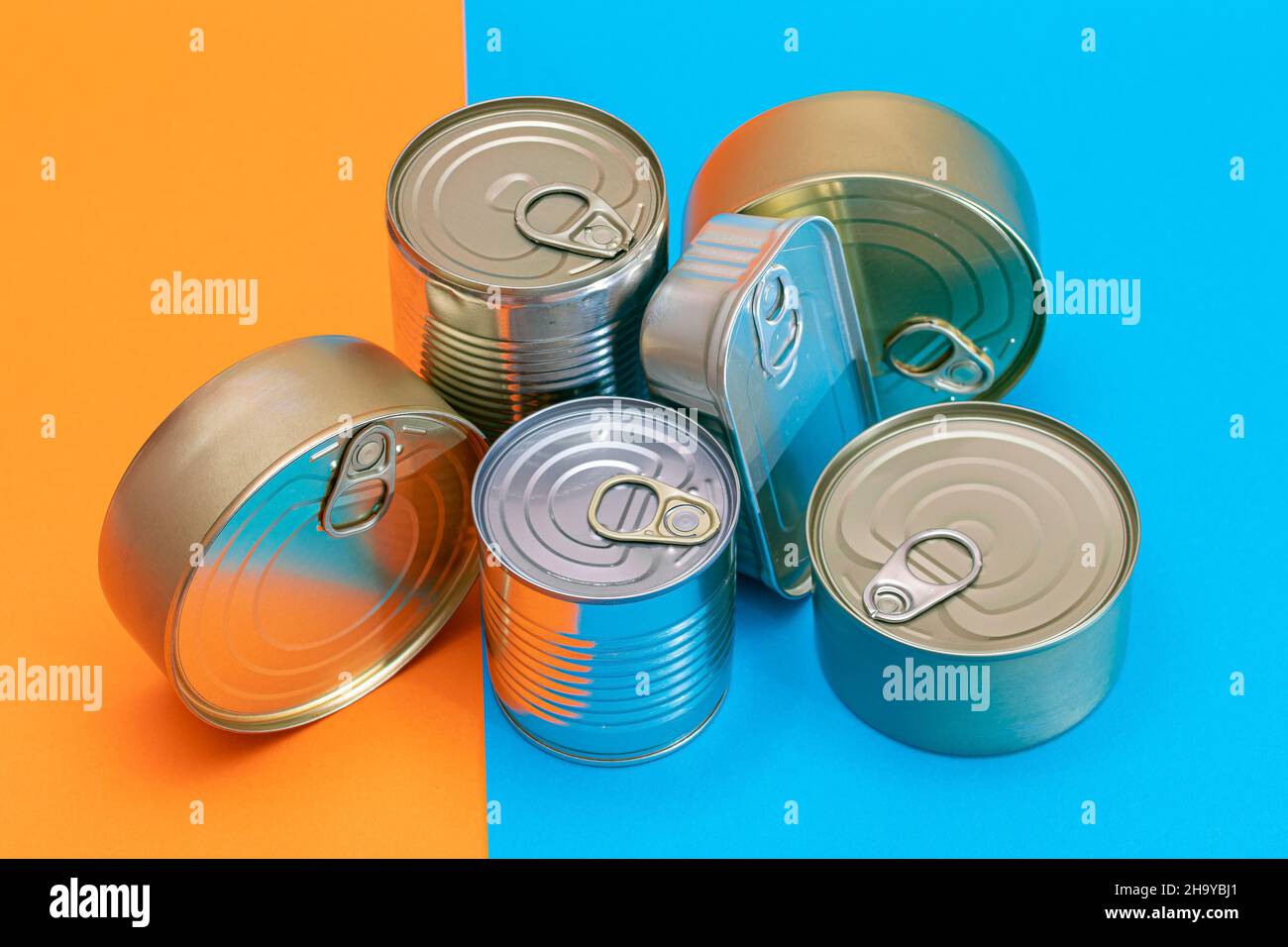 A Group of Stacked Tin Cans with Blank Edges on Split Blue and Orange ...