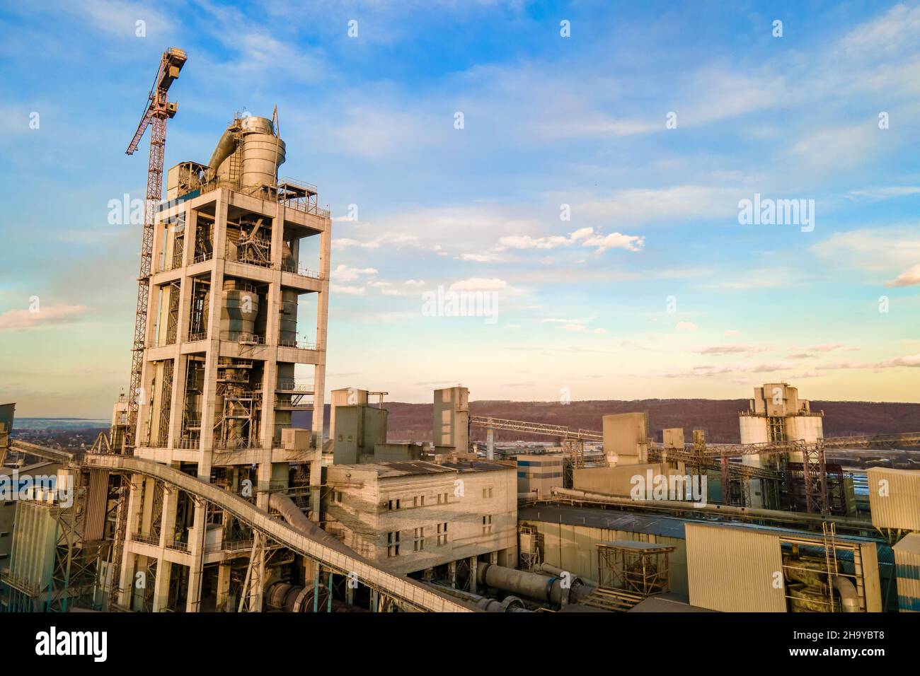 Aerial view of cement plant with high factory structure and tower crane ...