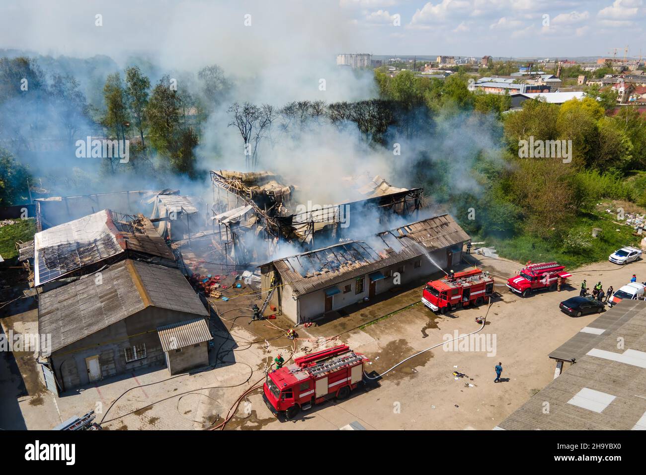 Aerial view of firefighters extinguishing ruined building on fire with ...