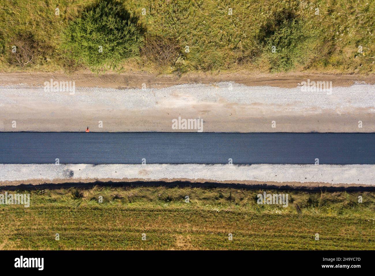 Aerial view of new road construction with newly layed black asphalt ...