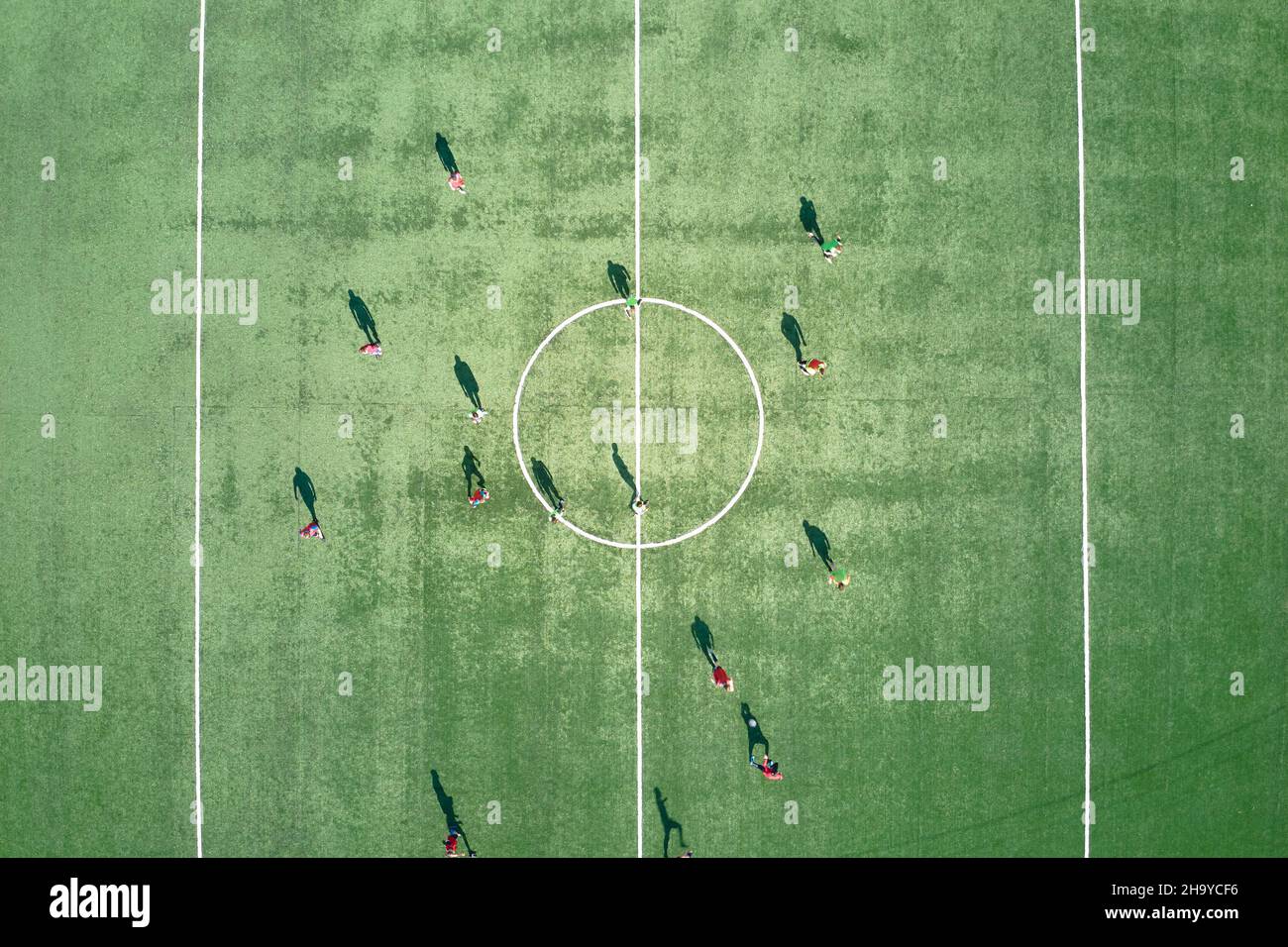 Aerial view of soccer players playing football on green sports stadium ...