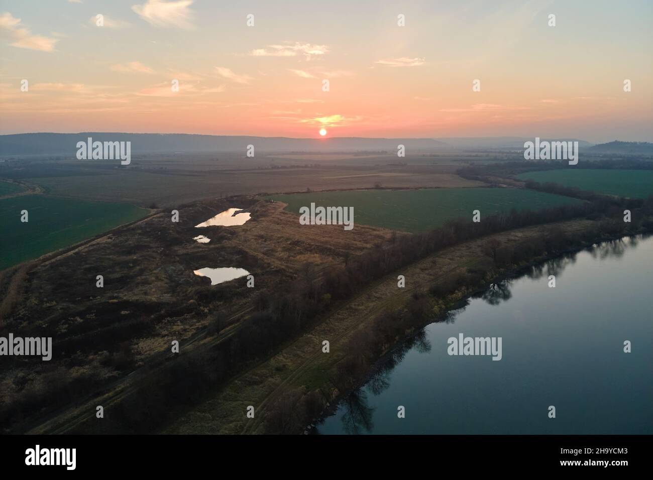 Aerial view of wide river flowing quietly in rural countryside in ...
