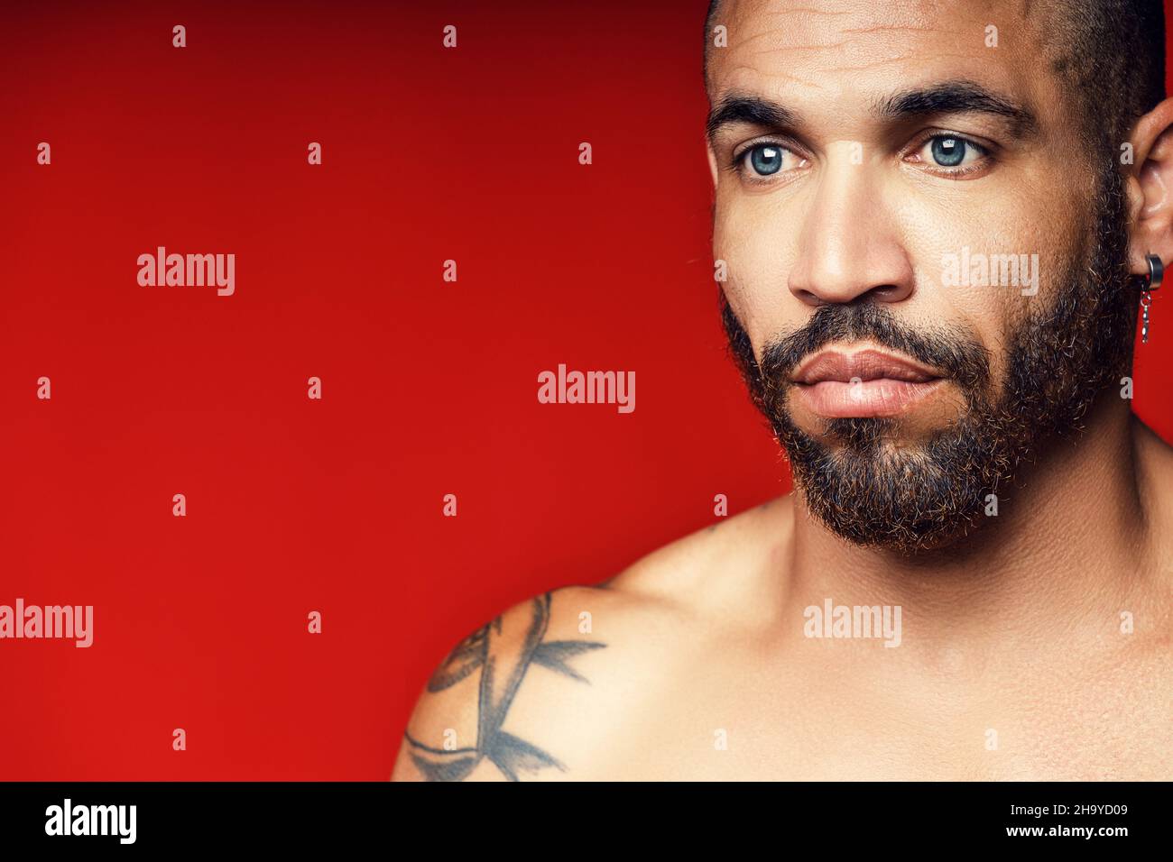 Face with a beard and an earring in the ear of a Cuban man close-up ...