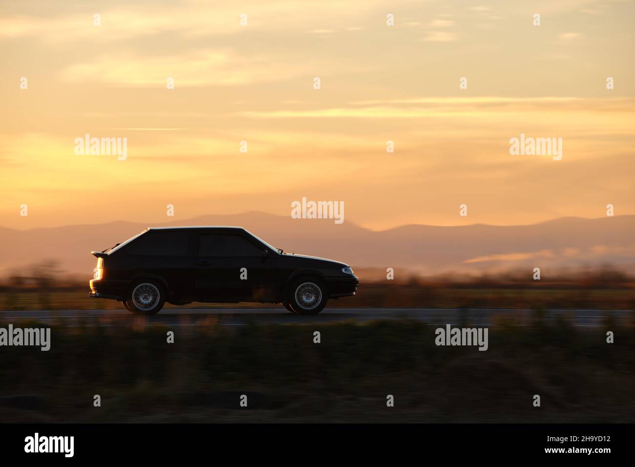 Car driving fast on intercity road at sunset. Highway traffic in ...