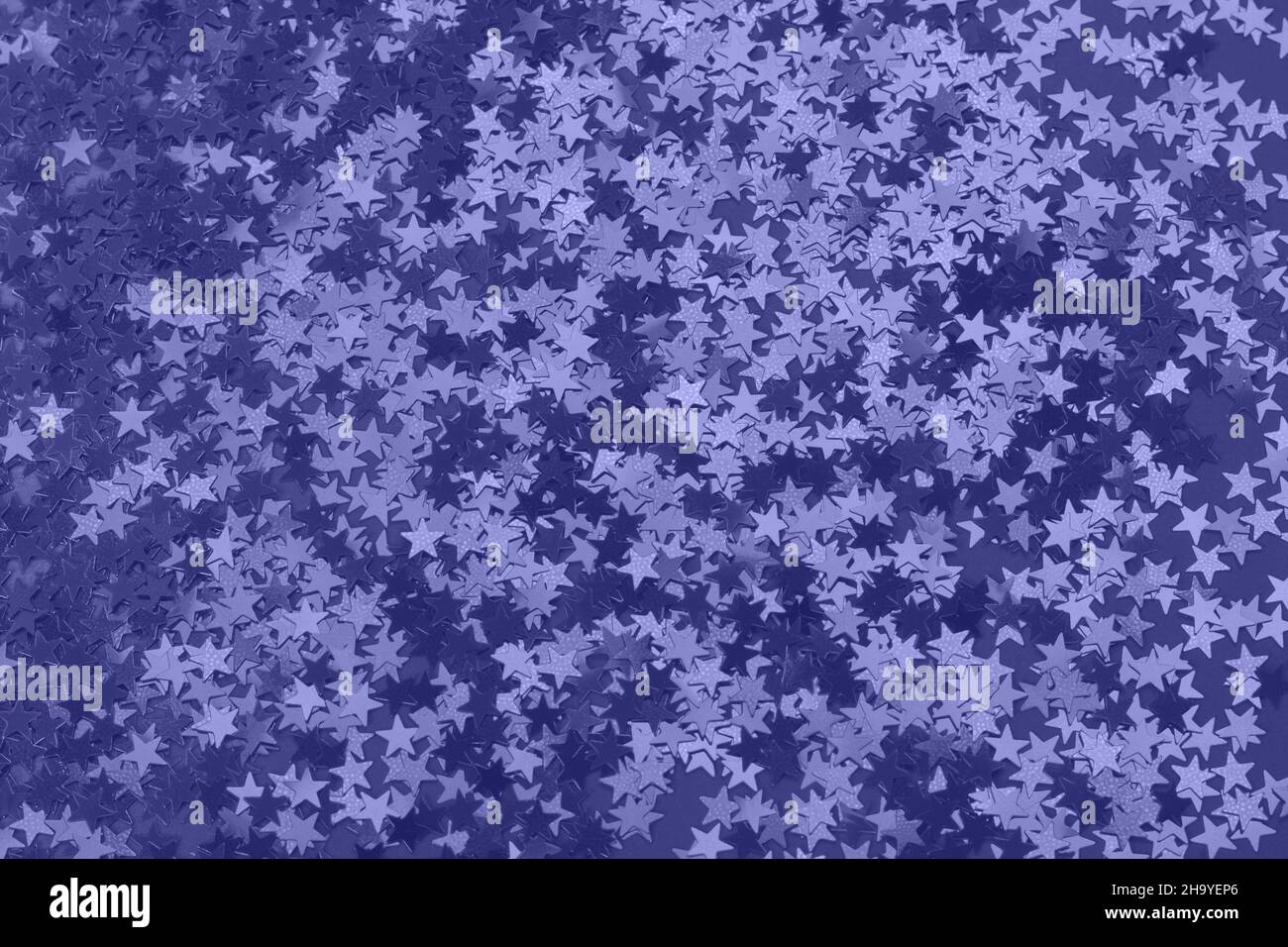 Metallic star shaped confetti on festive peri background Stock Photo ...