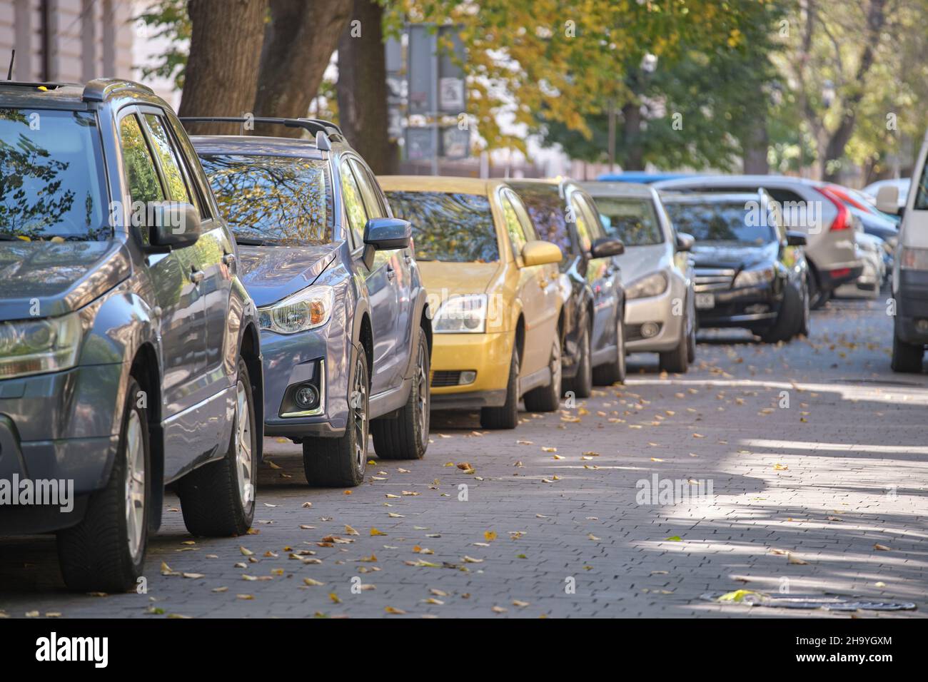 City traffic with many cars parked in line on street side Stock Photo ...