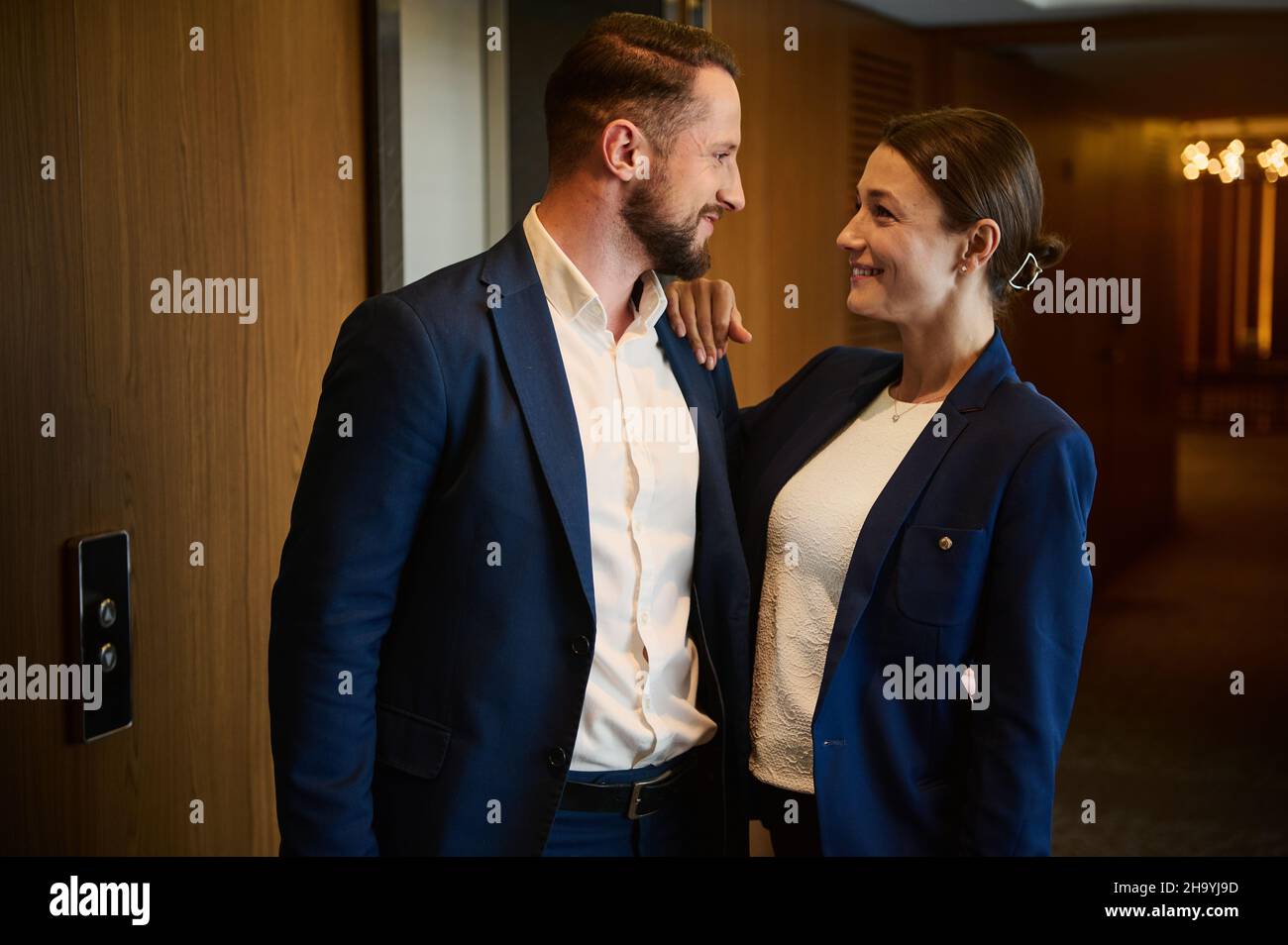 Two beautiful people, business partners, colleagues standing close to ...