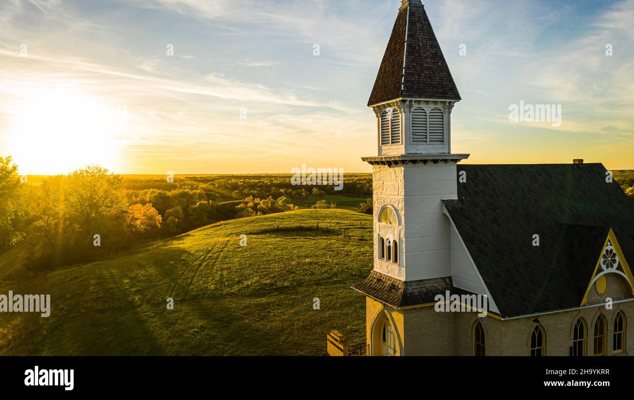 An old country church in the Great Plains during sunset with fall ...