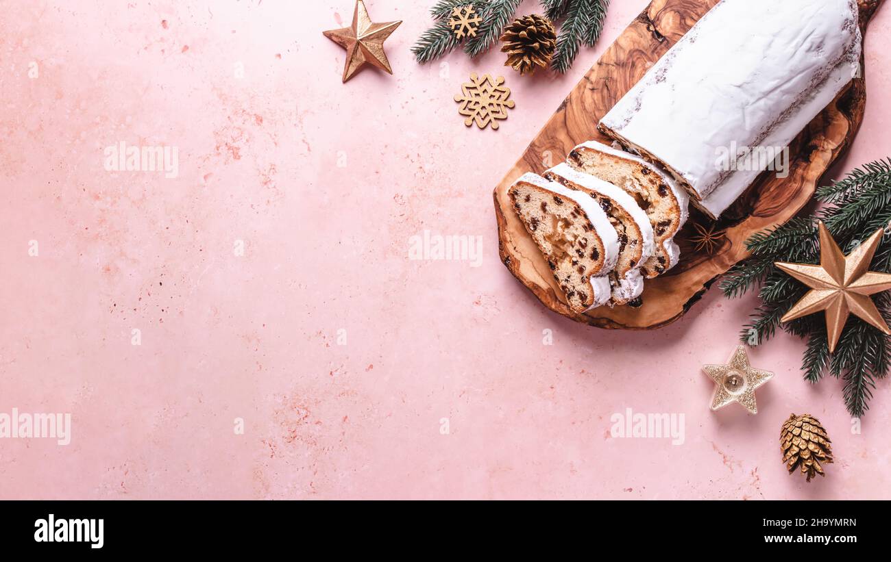 Border with Christmas Stollen cake, tree branches and golden decor on ...