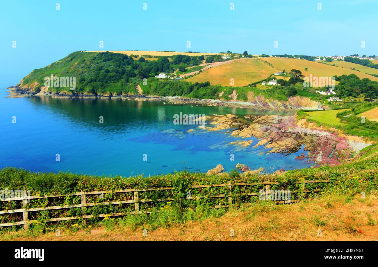 Talland Bay Cornwall UK with colourful red and purple rocks and clear ...