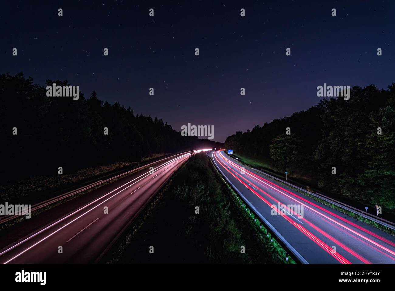 A german Autobahn at night with lighttrails of the fast driving cars in ...