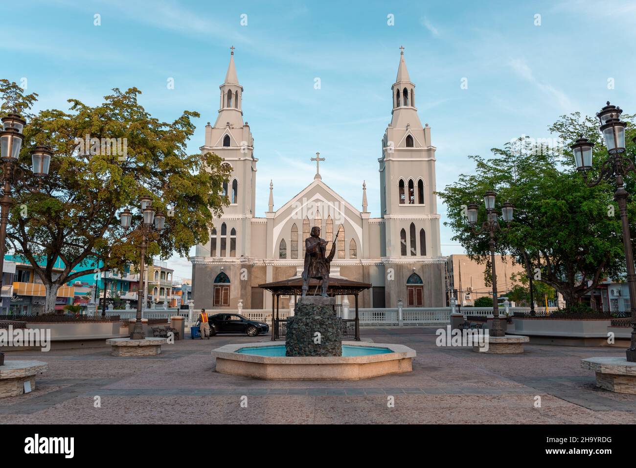 Statue of Christopher Columbus and an ancient church at the square of ...