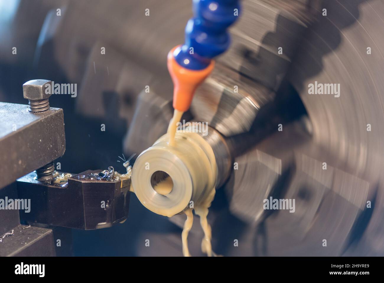 Turning metal on lathe using cooling fluid Stock Photo - Alamy