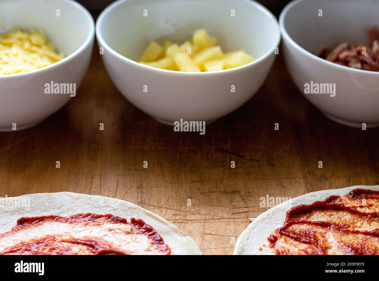 Pizza bases with additional ingredients in white bowls Stock Photo - Alamy