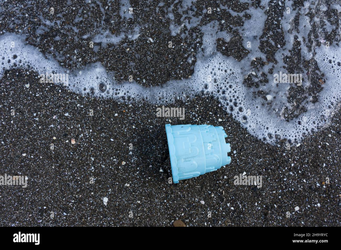 Blue plastic toy bucket partially buried in the sand Stock Photo - Alamy