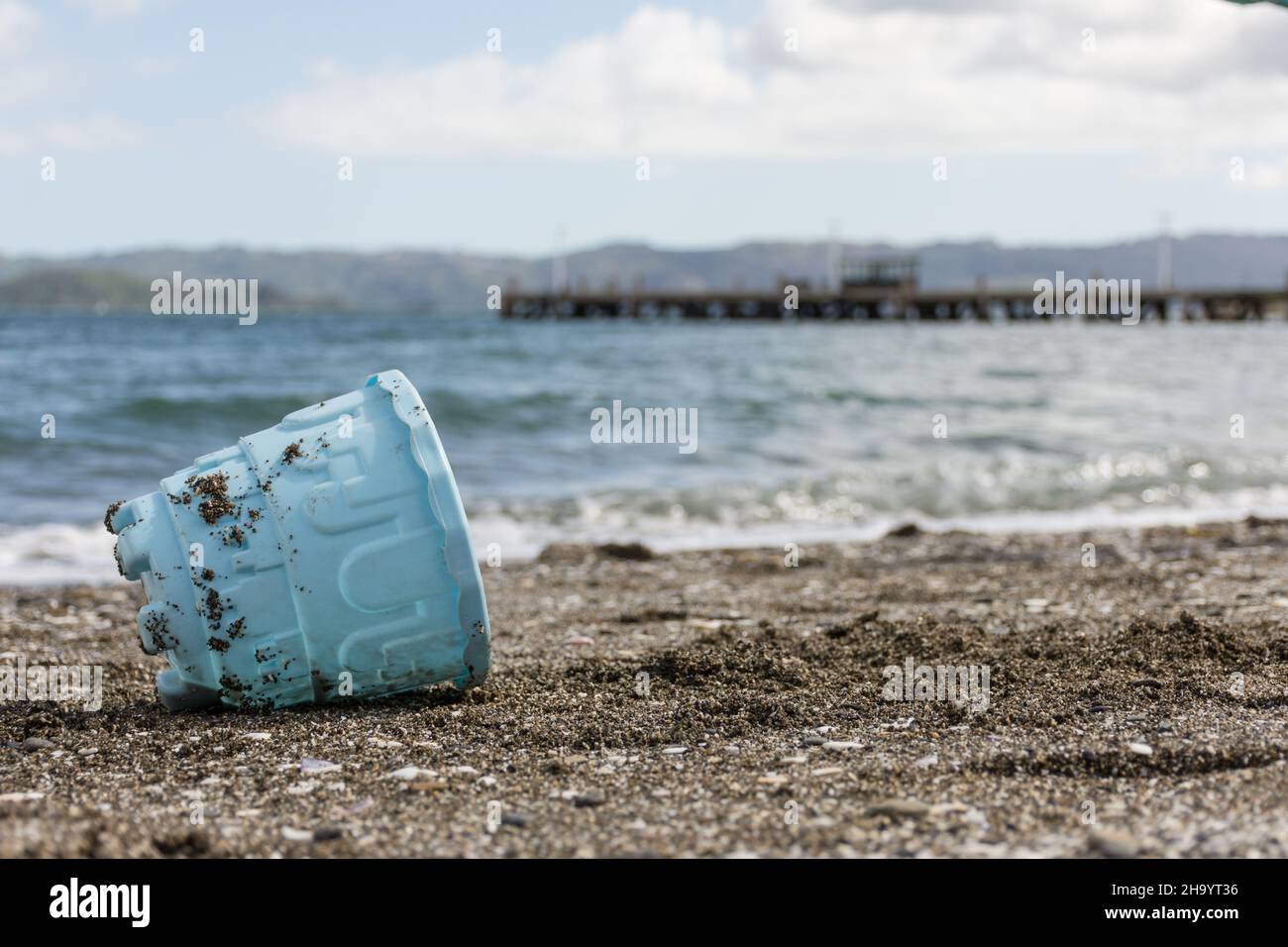 Blue plastic toy bucket partially buried in the sand Stock Photo - Alamy