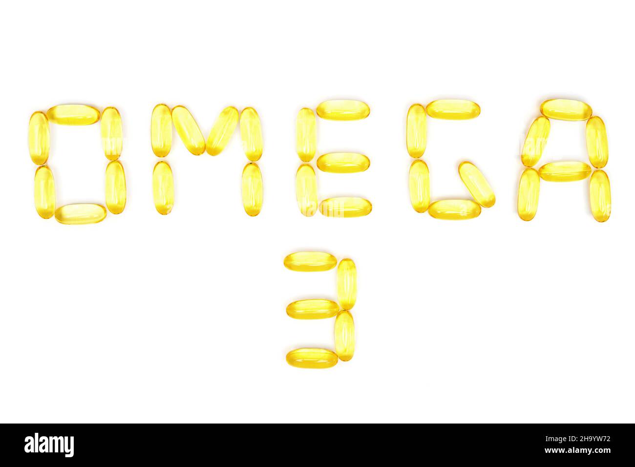 Fish oil soft gels arranged into a lettering OMEGA 3 isolated on white ...