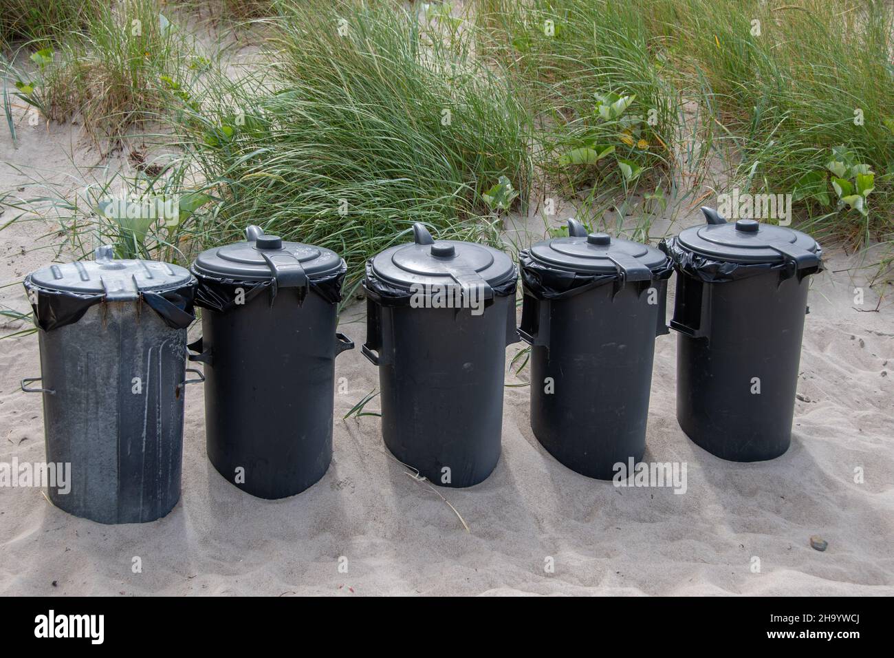 Five trash cans for garbage disposal on the beach Stock Photo - Alamy