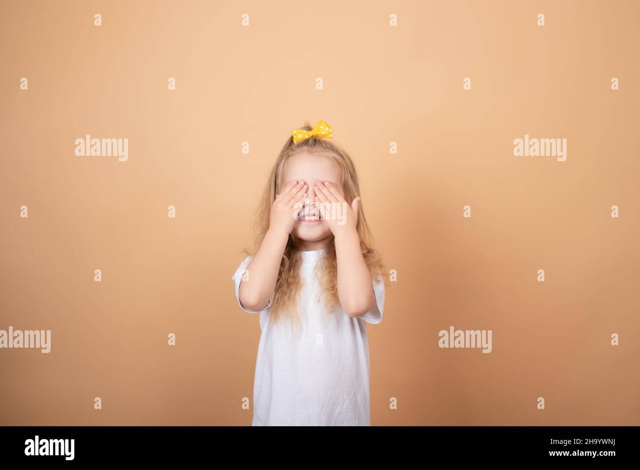 adorable blonde little girl in white t-shirt. on brown - yellow ...