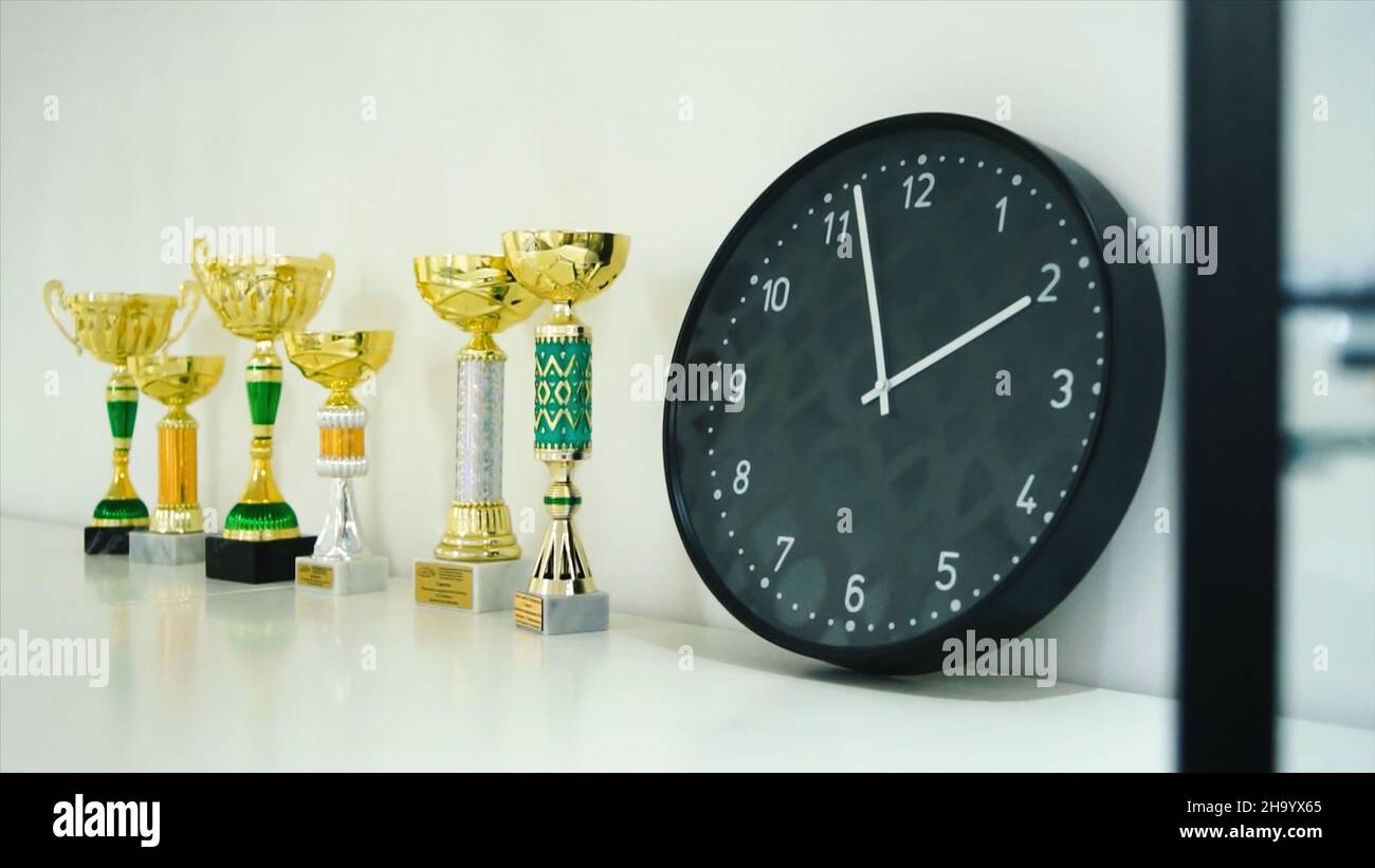 Trophy award for the winner show on shelf. Stock. Clock and trophies on ...