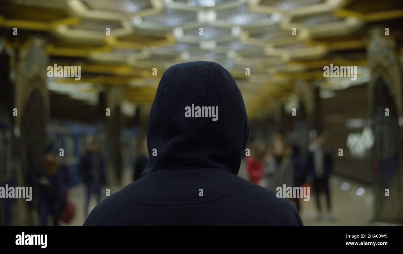 Rear view of a single hooded man in the subway. Concept of loneliness ...