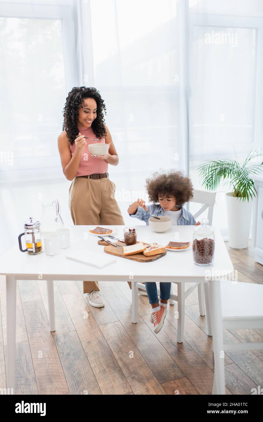African american family eating breakfast near chocolate paste and bread ...