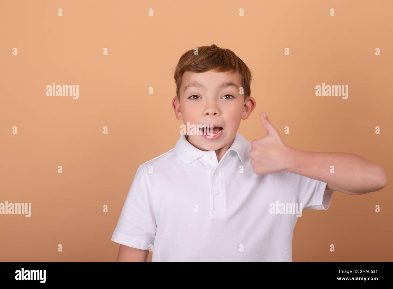 Things are good. Pretty school boy in white t-shirt looking at the ...